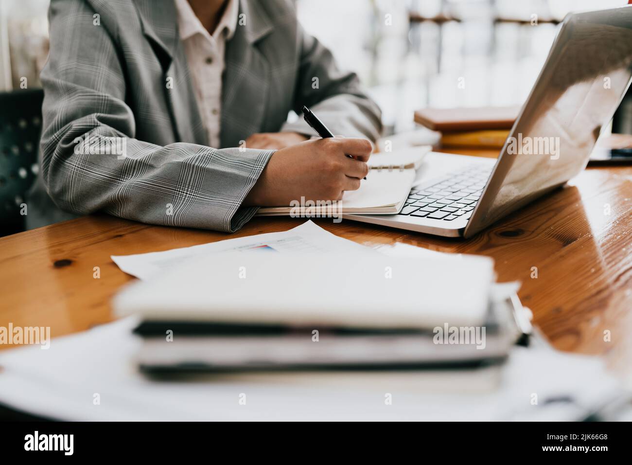 woman writing making list taking notes in notepad working on laptop ...