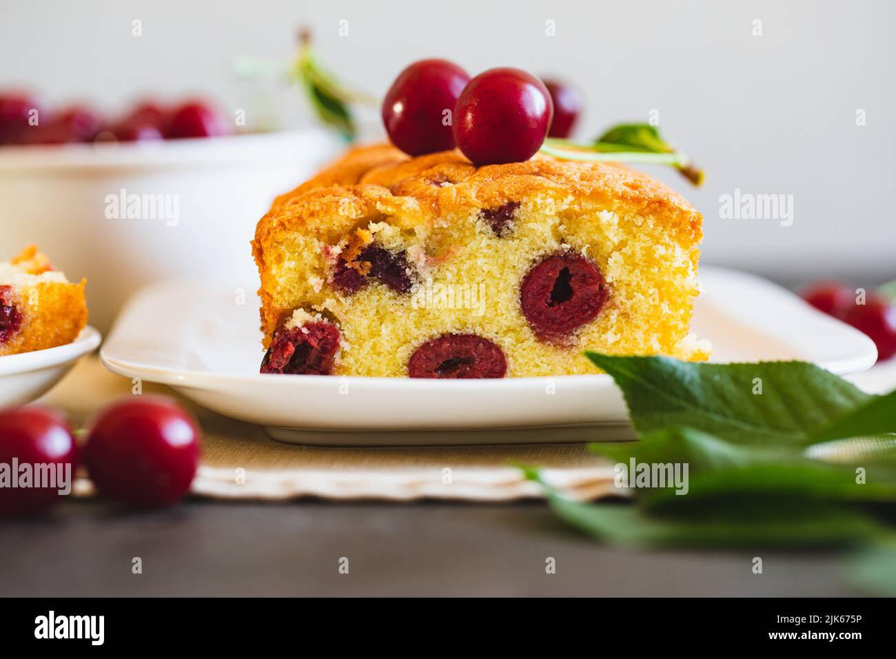 delicious sweet cake with cherries and a fresh cherry on the side ...