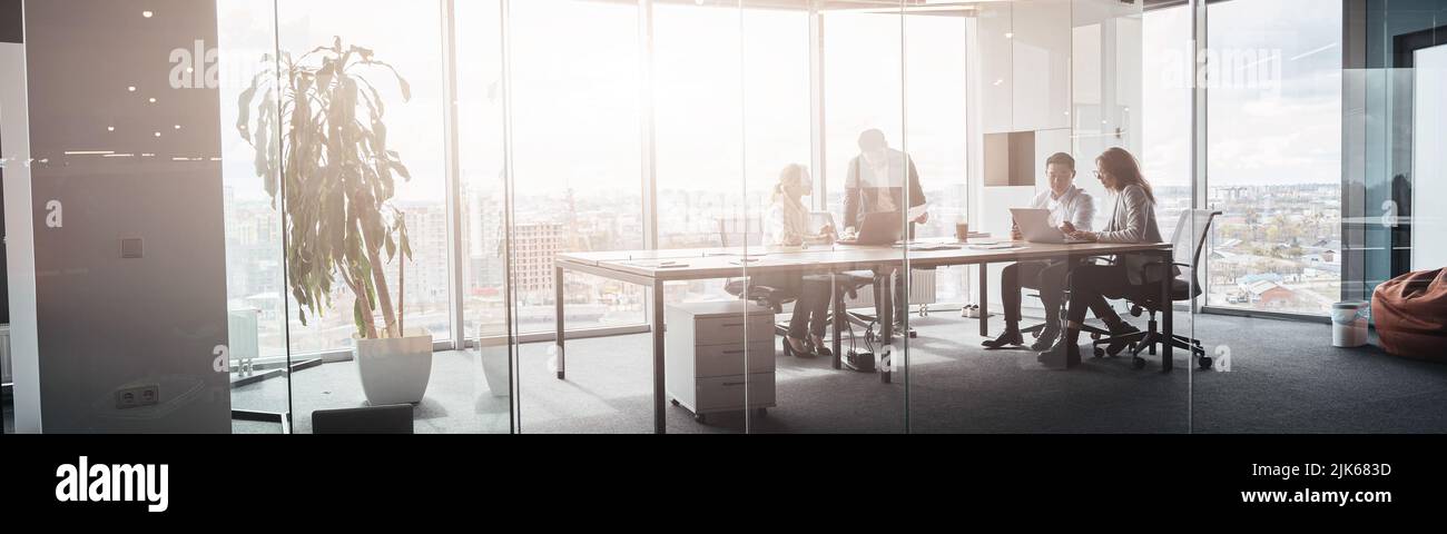 Team of businessmen communicating together in modern office with ...
