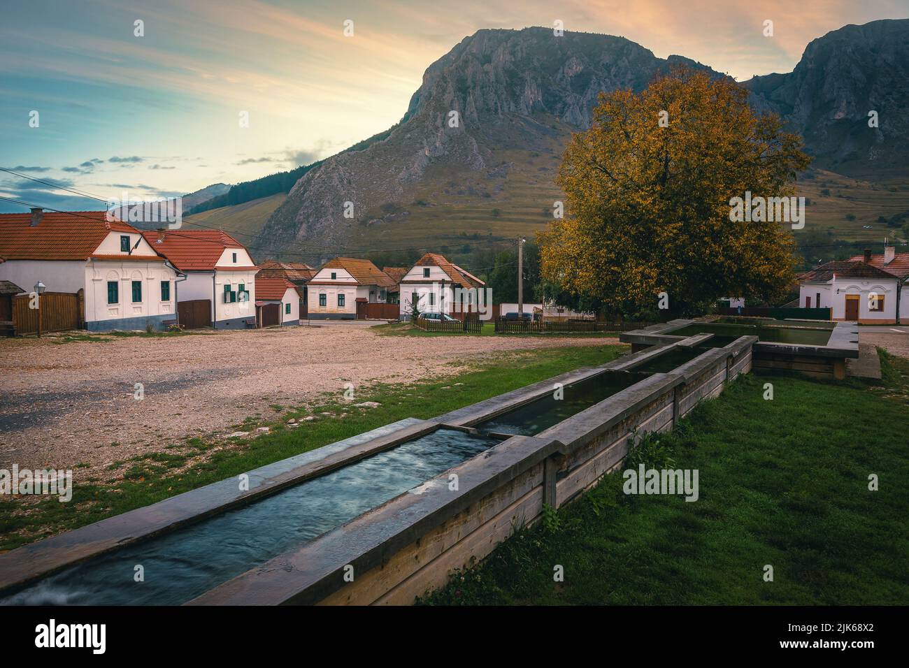 Majestic rural street view with traditional houses in row and fountain ...