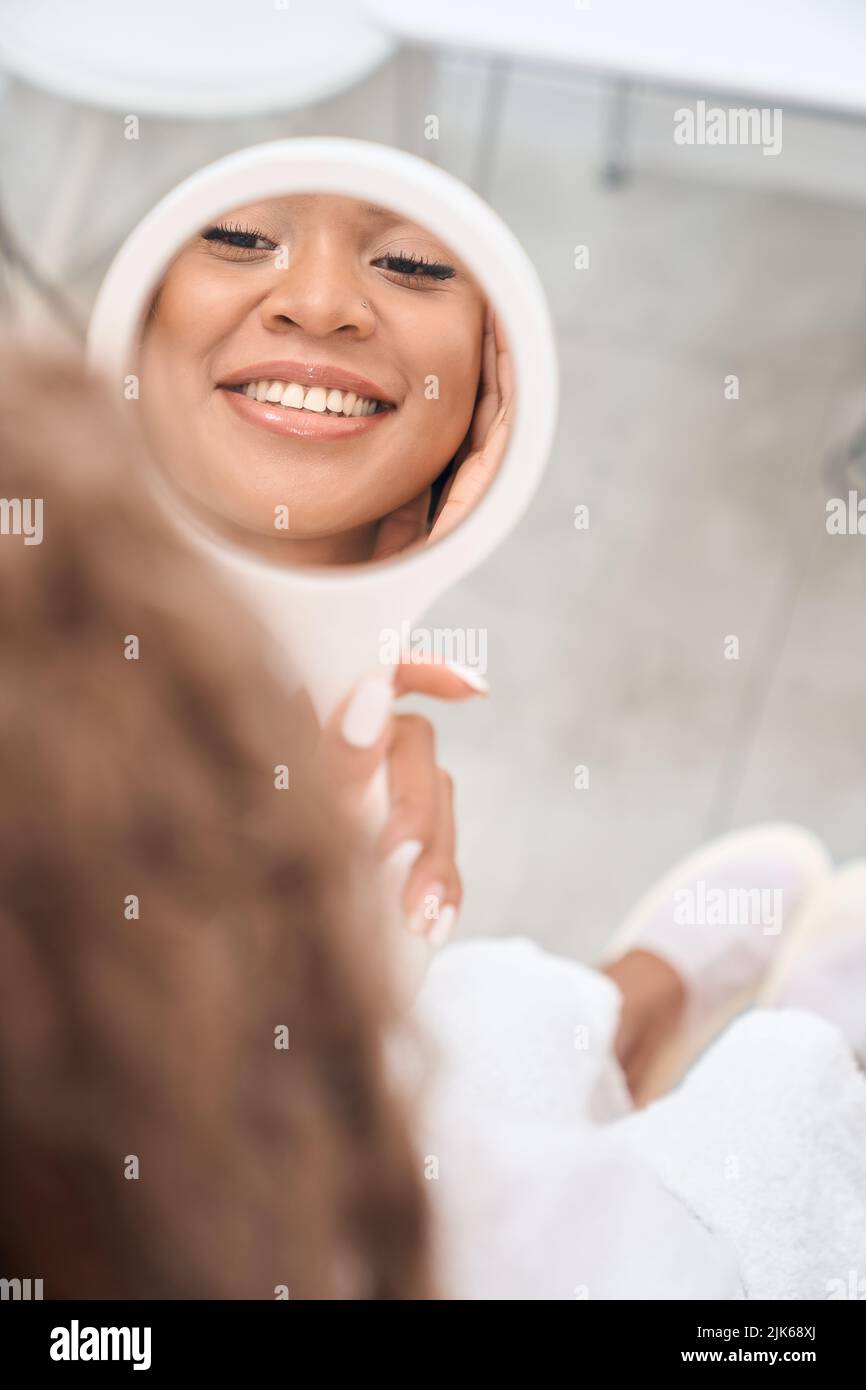Woman admiring her reflection in the mirror Stock Photo - Alamy