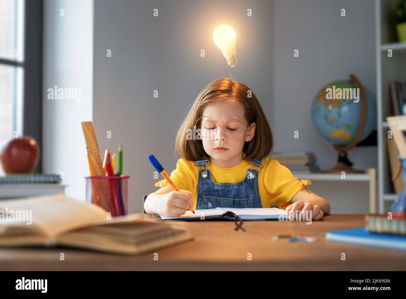 Back to school. Thinking child is sitting at desk. Girl doing homework ...