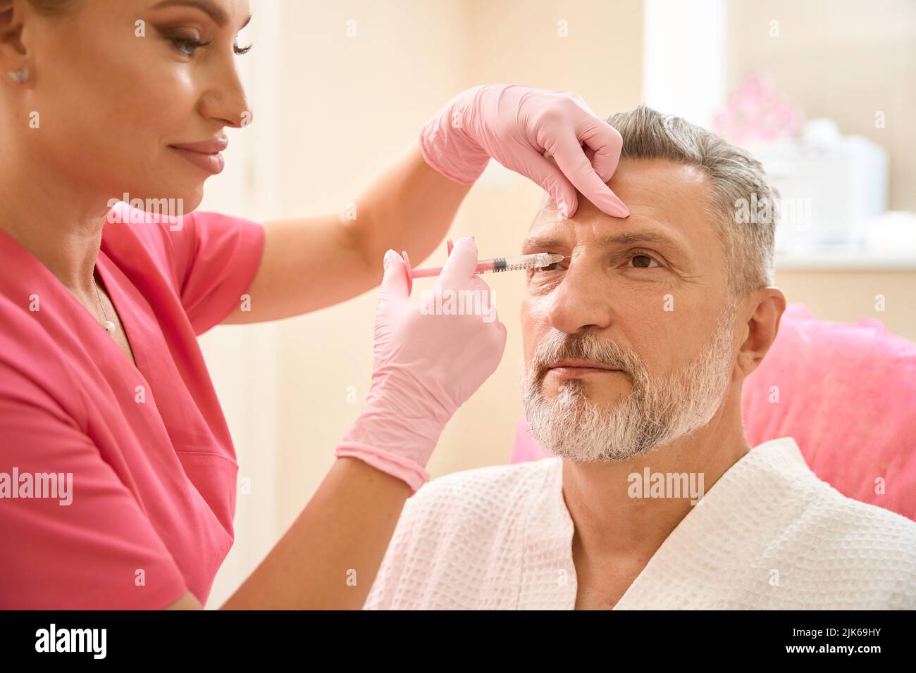 Pretty female cosmetologist injects beauty injection into bridge of ...