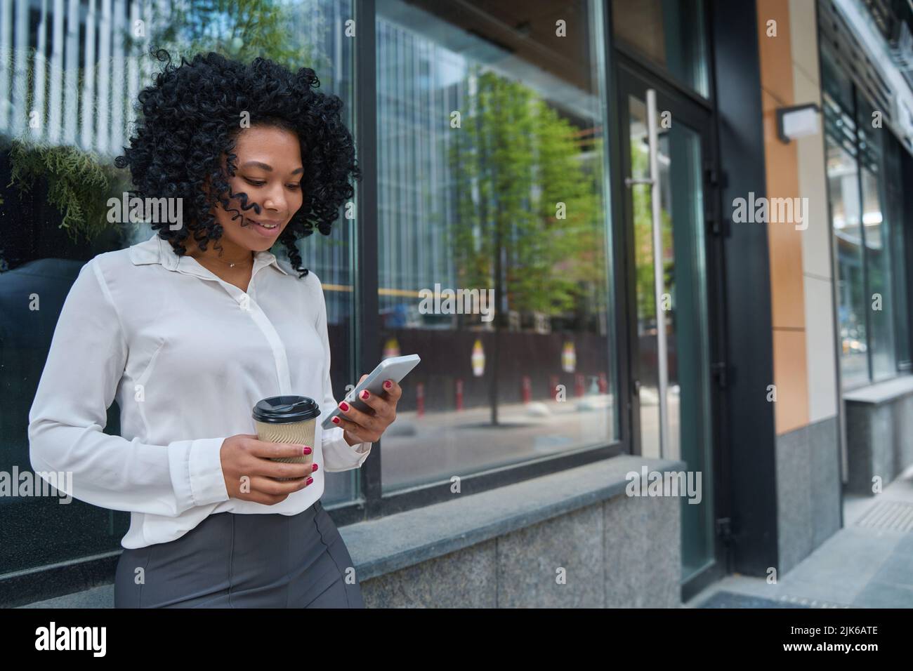 Female holding coffee in hands and reading message on phone Stock Photo ...