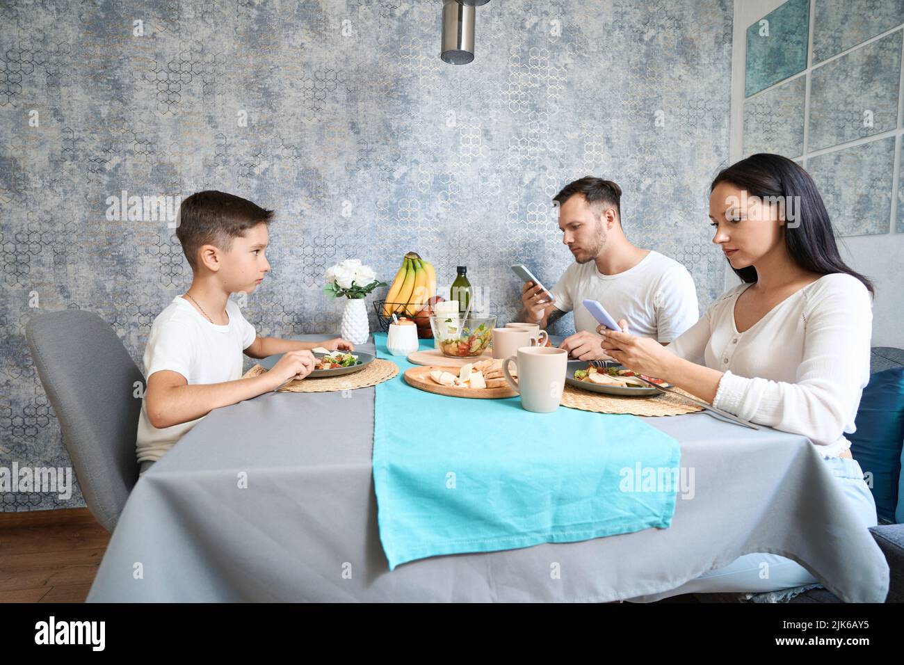 Typical family with smartphones at the dinner table Stock Photo - Alamy