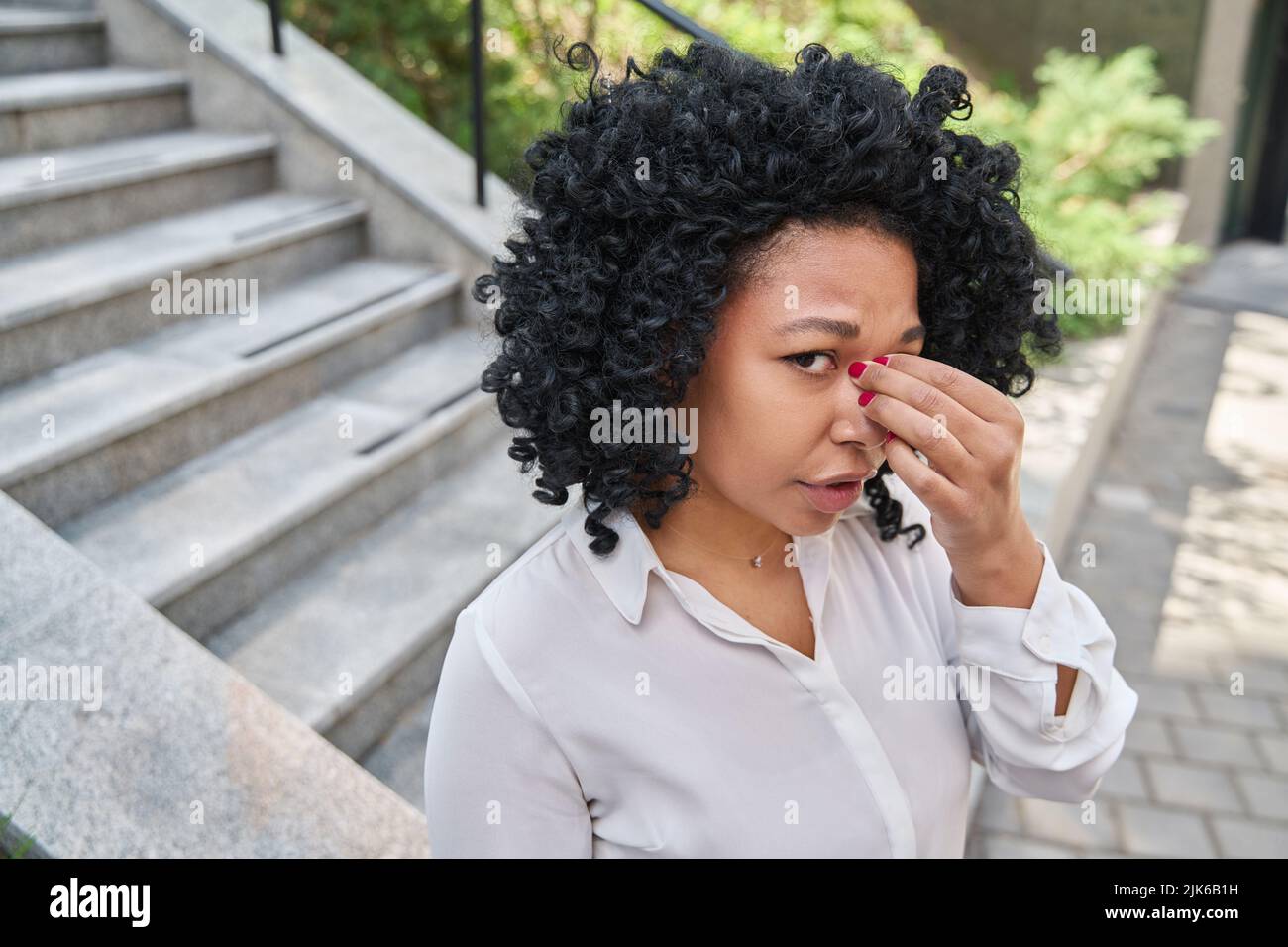 Woman suffering from pain and pinching the bridge of her nose Stock ...