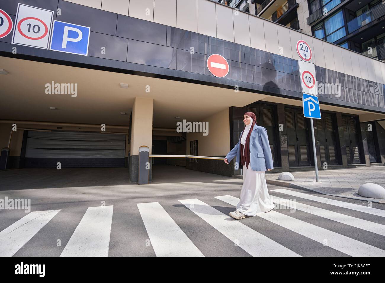 Arab woman crosses the road near the parking lot on a zebra Stock Photo ...