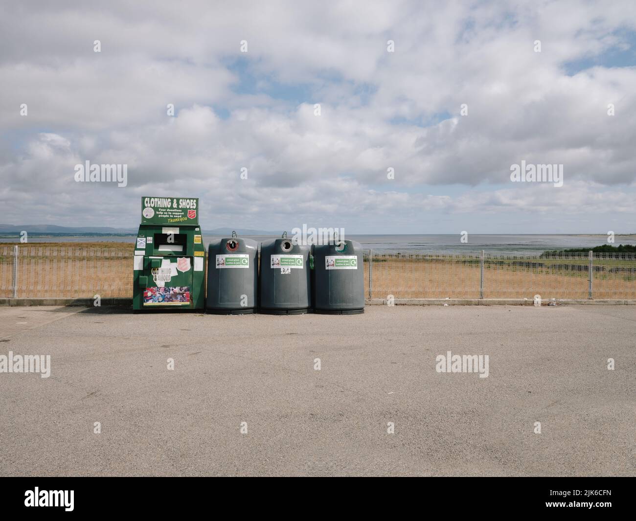 A recycling point with receptacles in an empty car park for clothes ...
