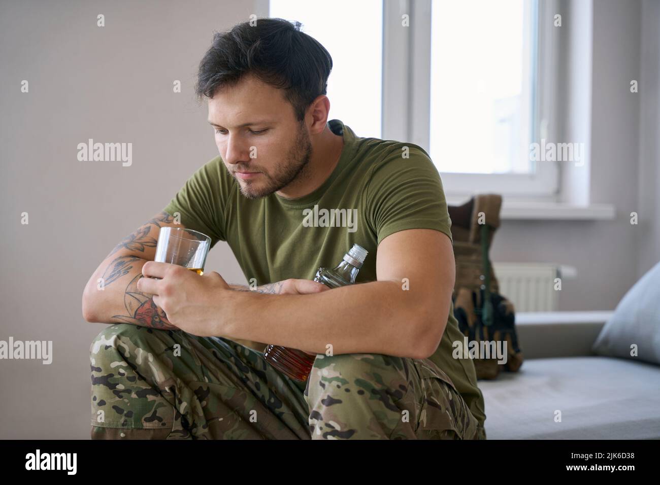 Army man staring at bottom of glass with alcoholic drink Stock Photo ...