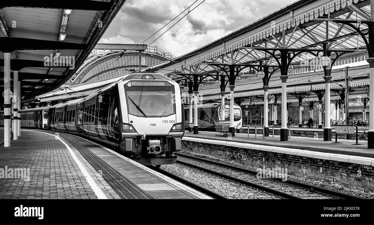 A locomotive rests near a historic canopy with a metal arch behind. A ...
