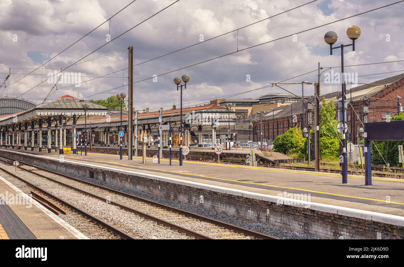 Historic canopies stand on a railway station platform in the sunshine ...
