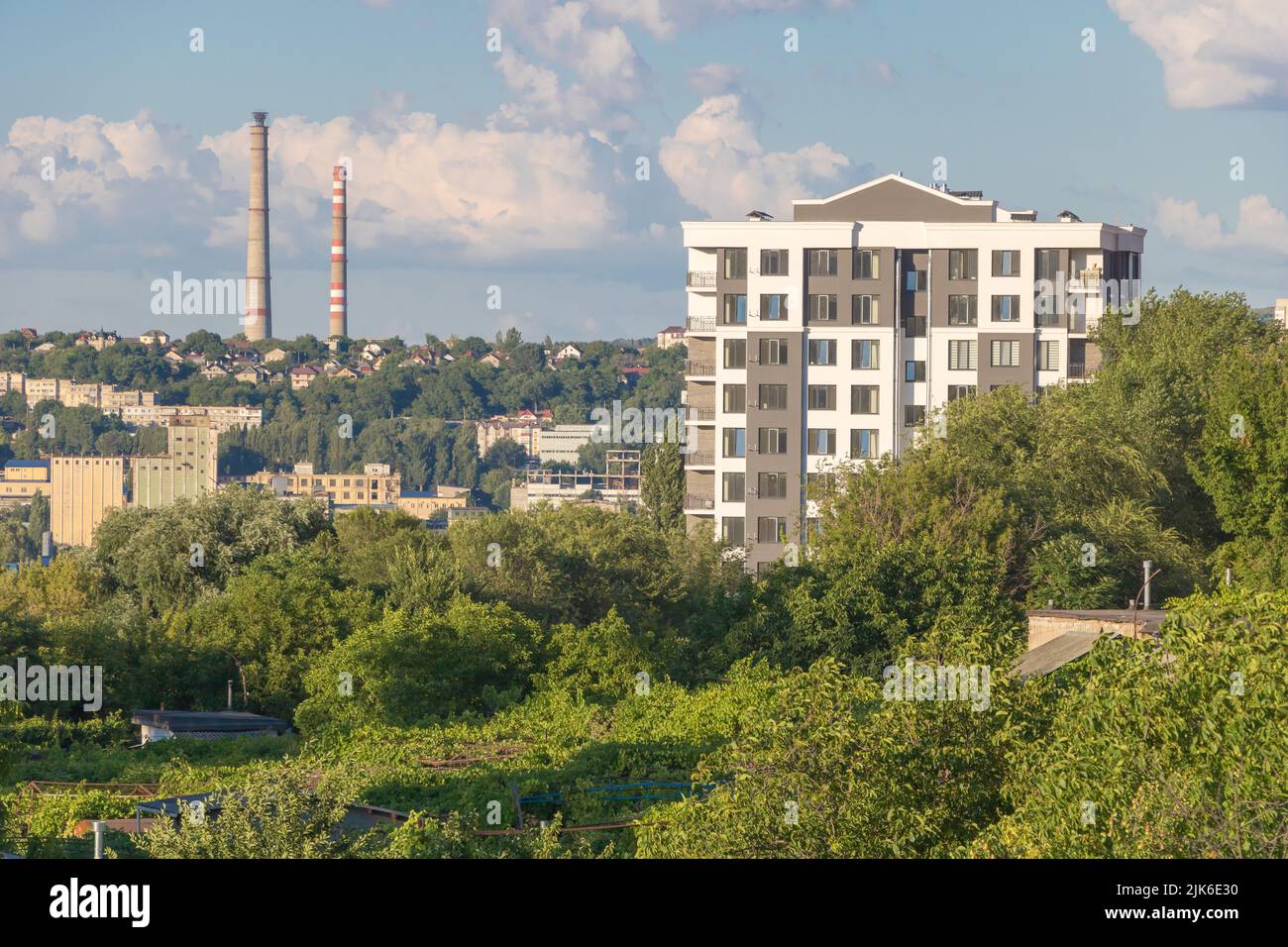 High rise apartment building on nice summer day with industrial factory ...