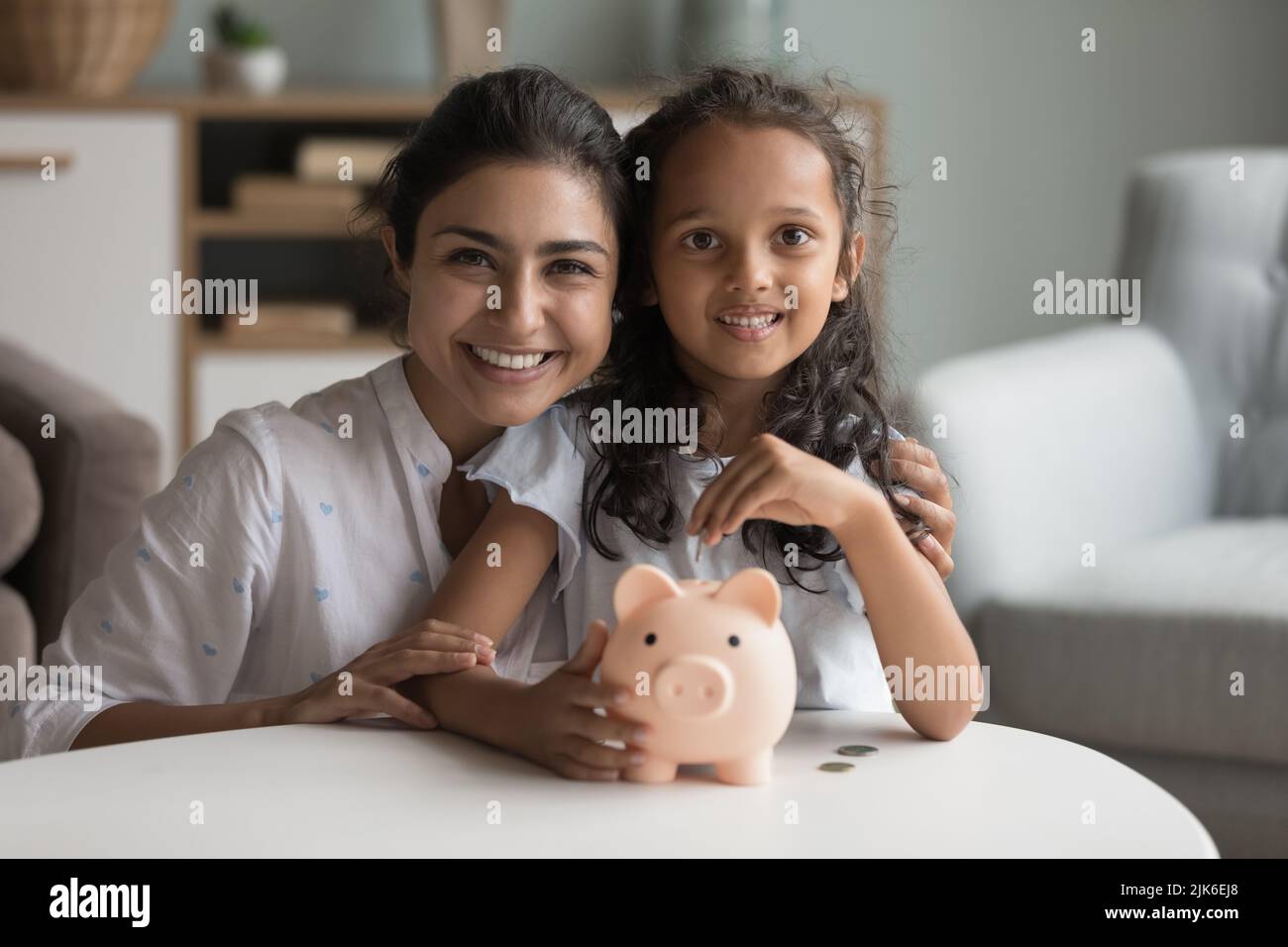 Happy beautiful Indian mother and kid girl saving money Stock Photo - Alamy