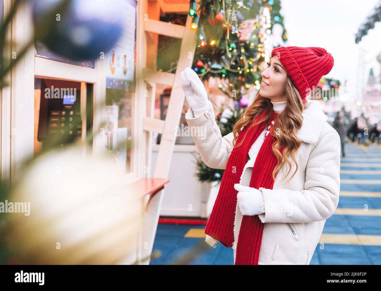 Young happy woman with curly hair in red knitted hat on shopping at ...