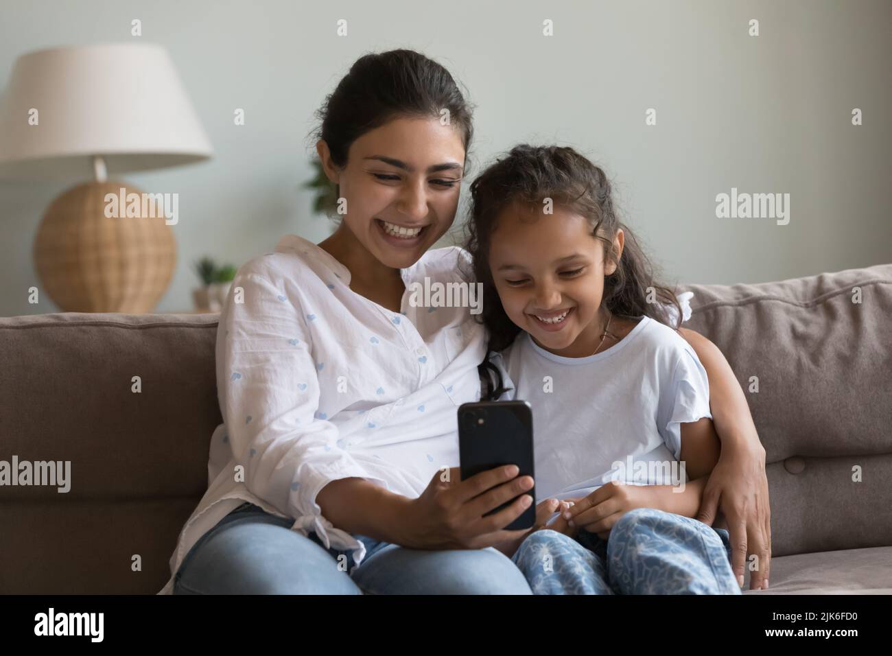 Happy Indian mum hugging kid, sitting on couch at home Stock Photo - Alamy