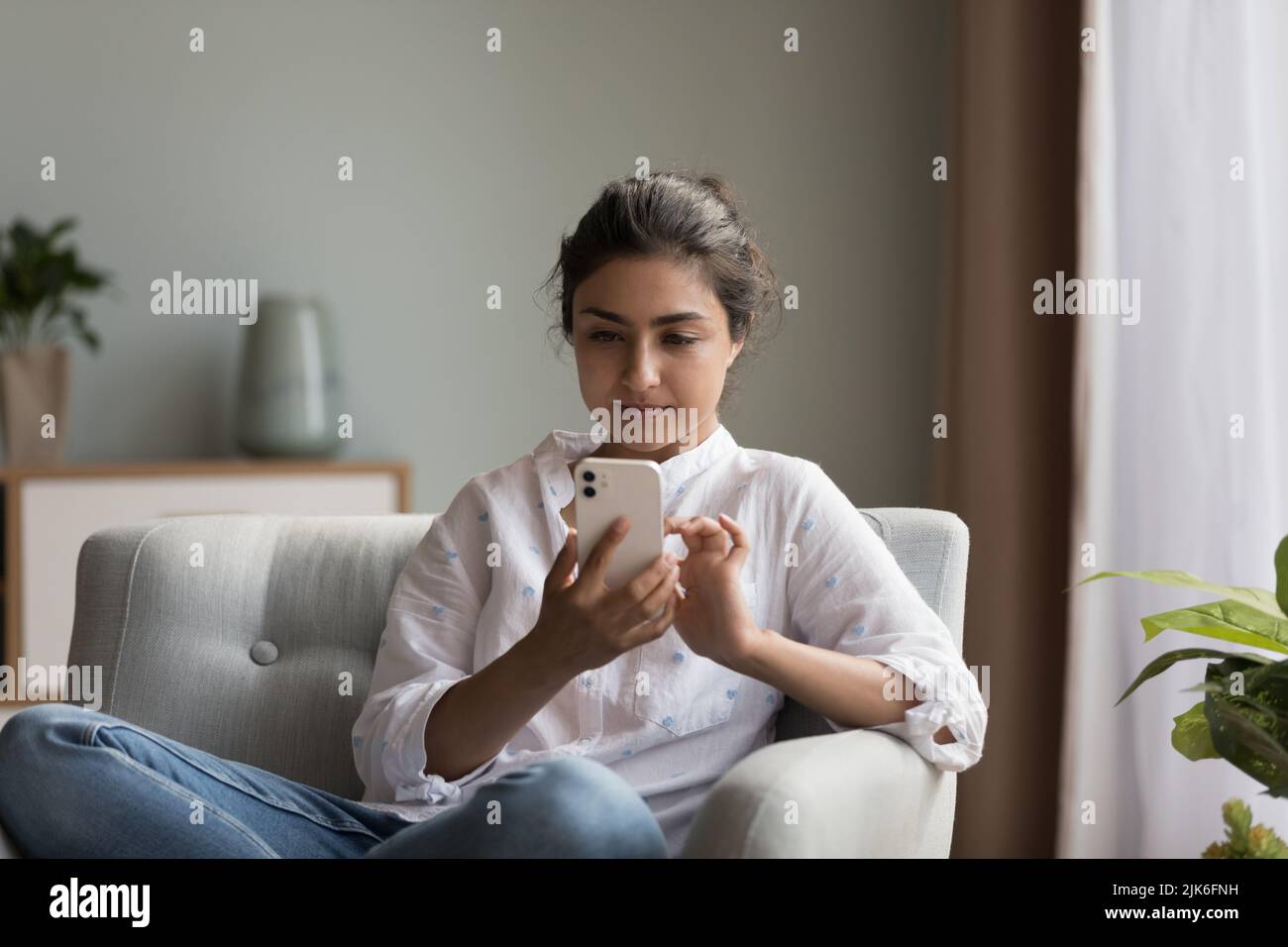 Focused beautiful Indian smartphone user woman texting message Stock ...