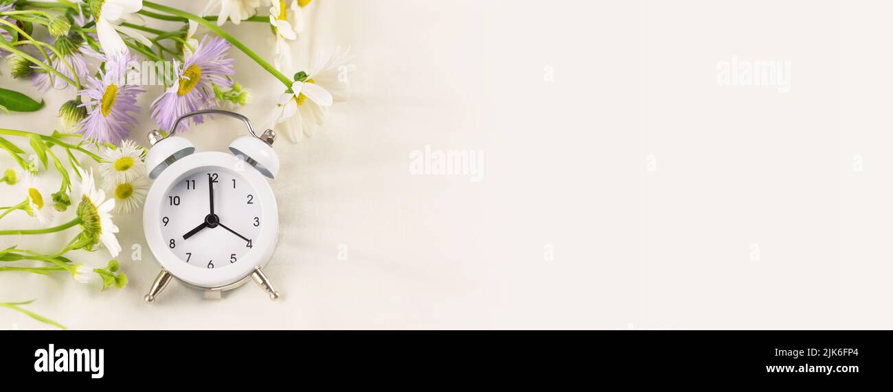 Good morning banner with wild flowers and alarm clock on a white ...