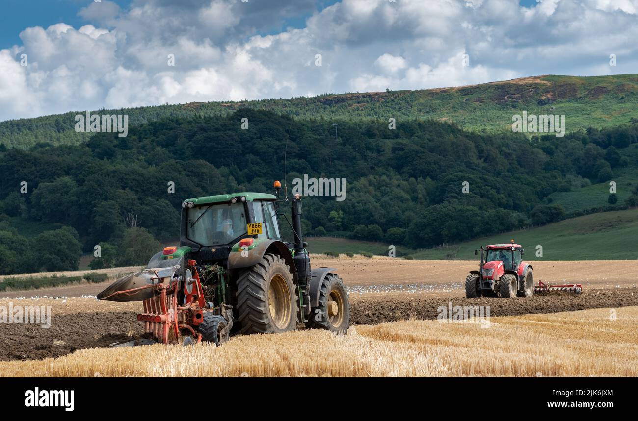 Farmers ploughing and cultivating an arable field after harvest. North ...