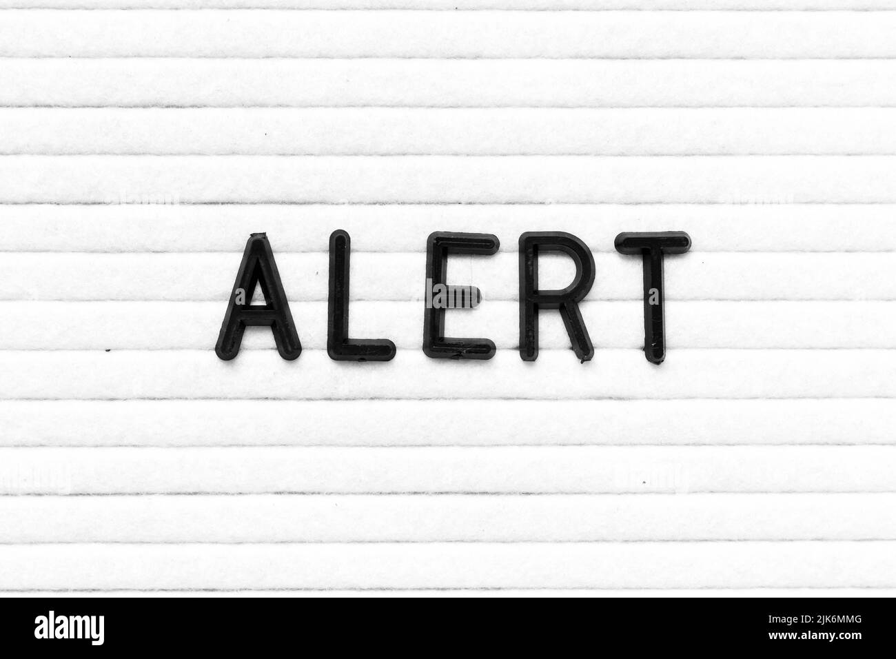 Black color letter in word alert on white felt board background Stock ...