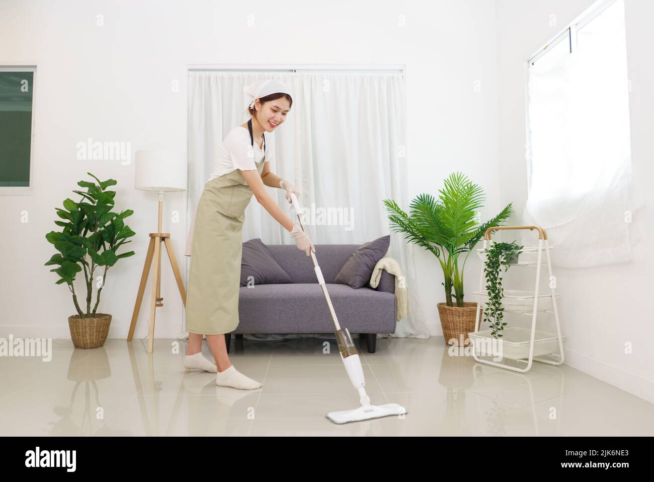 Lifestyle in living room concept, Young Asian woman cleaning the floor ...