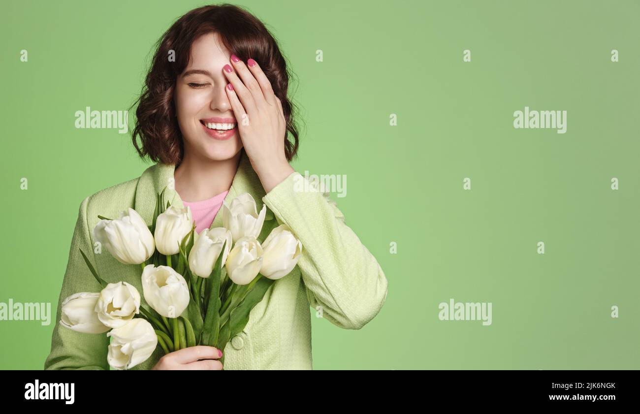 Happy brunette girl receives bouquet of flowers. Laughing woman with ...