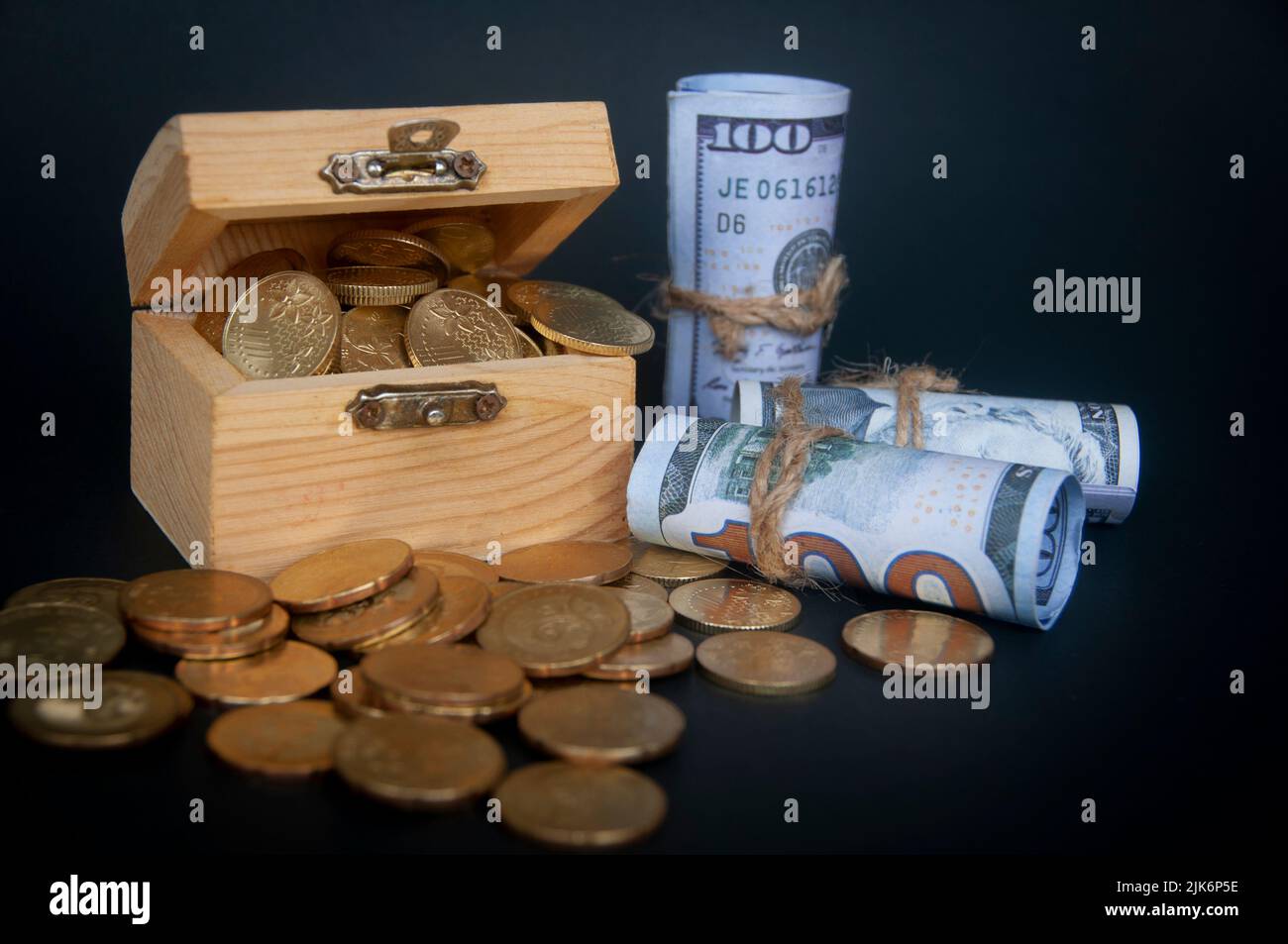 Gold coins in treasure chest and bank notes isolated on dark background ...