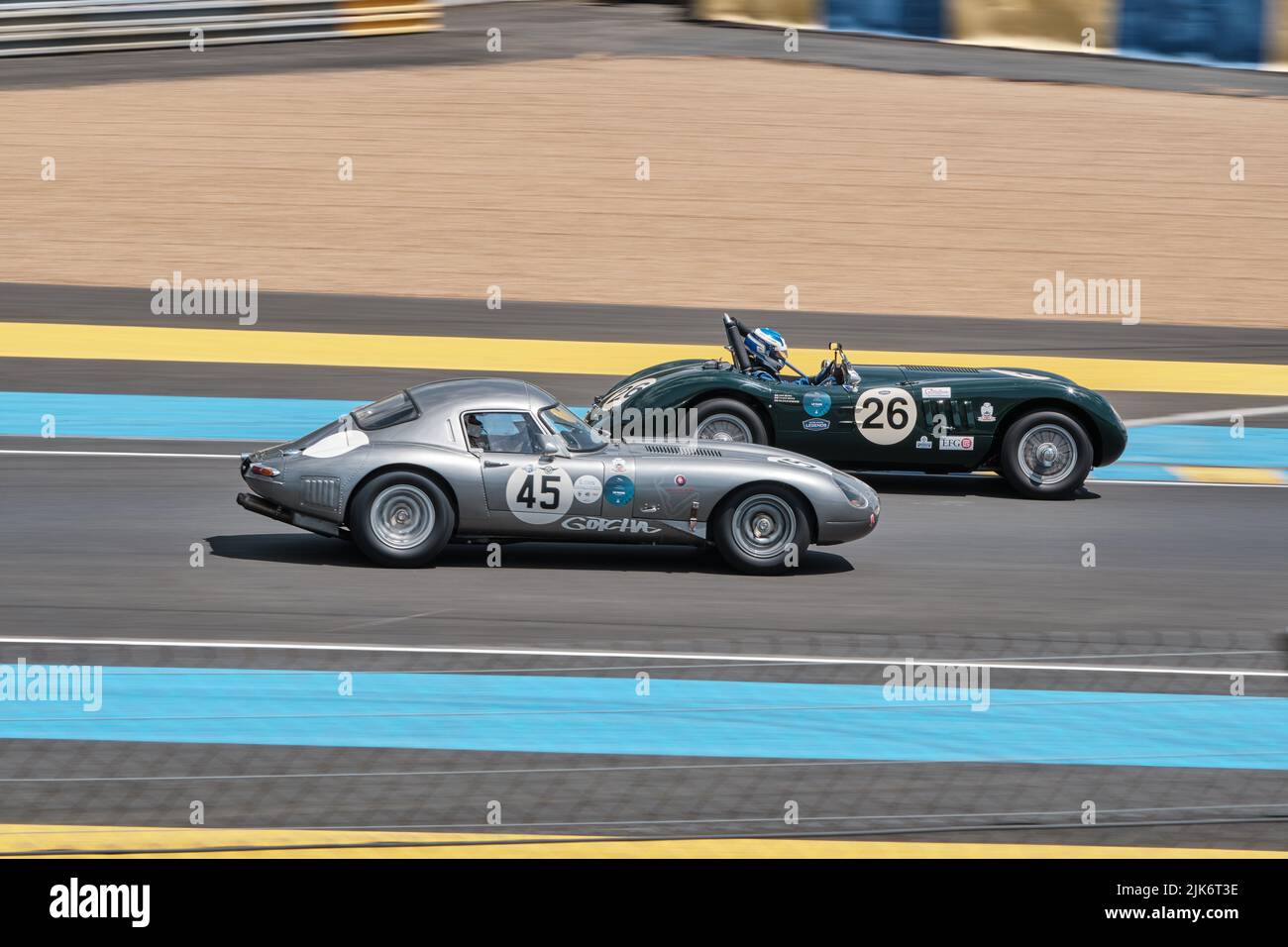 Two race cars driving from left to right on a racetrack Stock Photo - Alamy