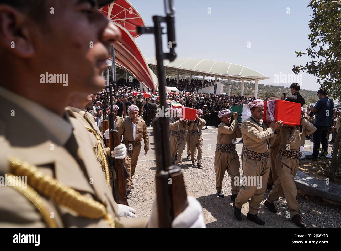 Barzan, Iraq. 31st July, 2022. Kurdish men carry coffins containing the ...