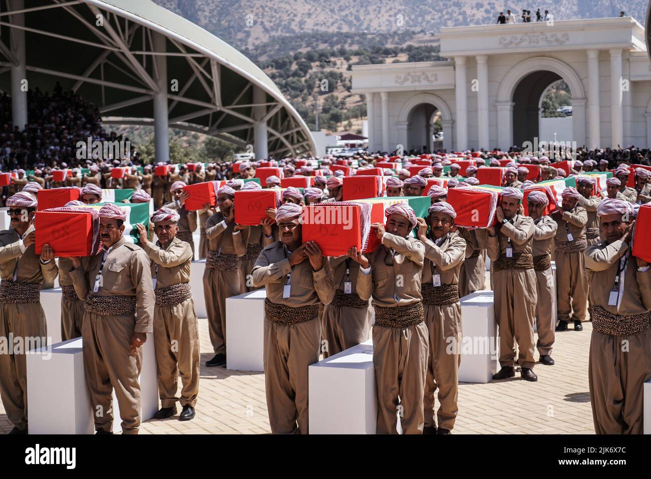 Barzan, Iraq. 31st July, 2022. Kurdish men carry coffins containing the ...