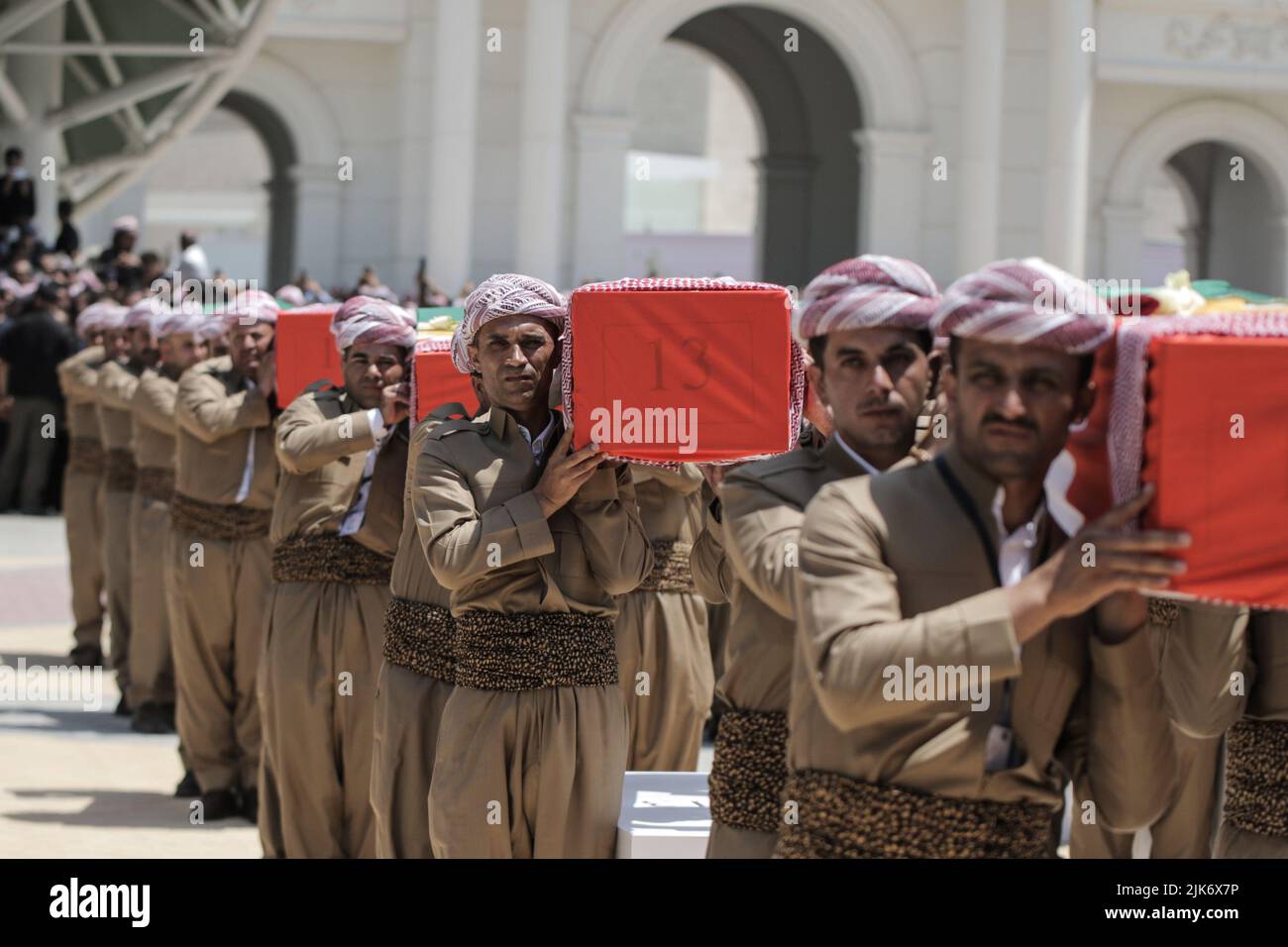 Barzan, Iraq. 31st July, 2022. Kurdish men carry coffins containing the ...