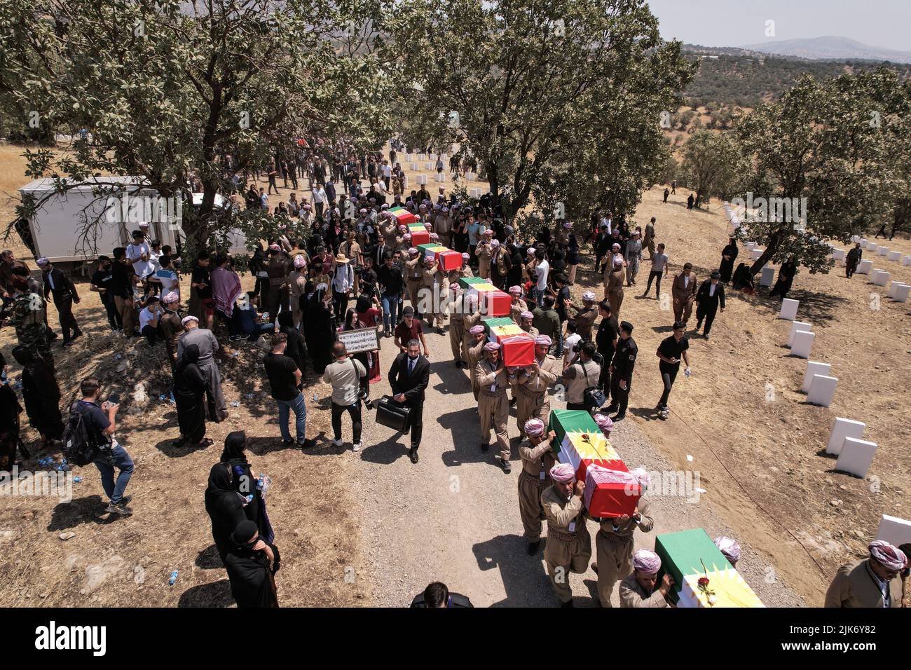 Barzan, Iraq. 31st July, 2022. Kurdish men carry coffins containing the ...