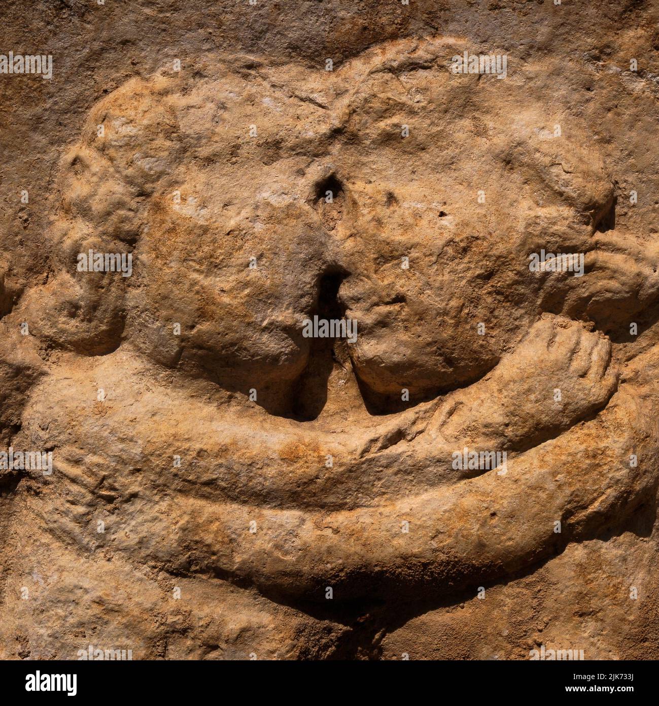 Embracing putti or cherubs, sculpted in relief on a plundered stone ...