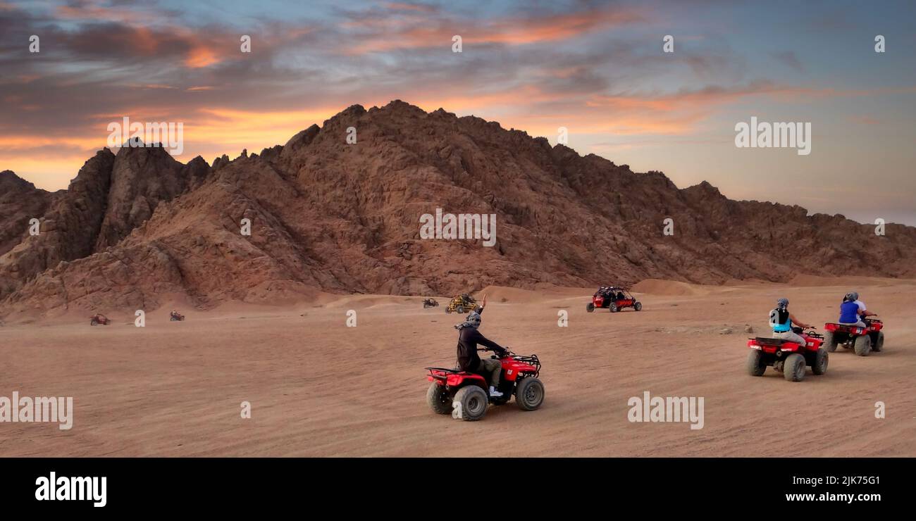 An unrecognizable man on a red quad bike in the Egyptian desert of ...