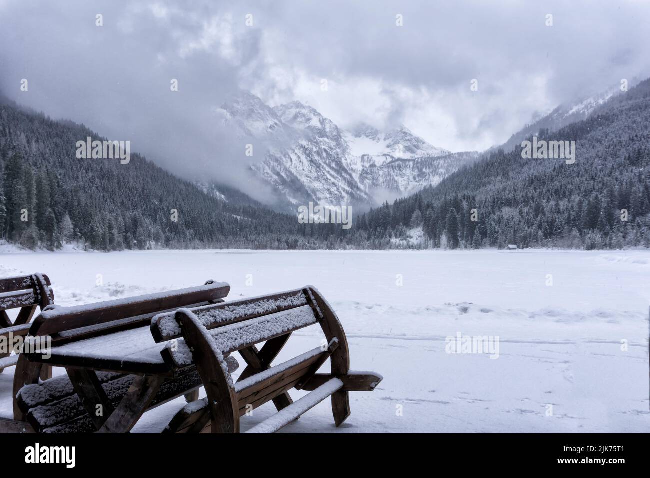 Winter landscape with frozen lake, sorrounded rocky mountains covered ...