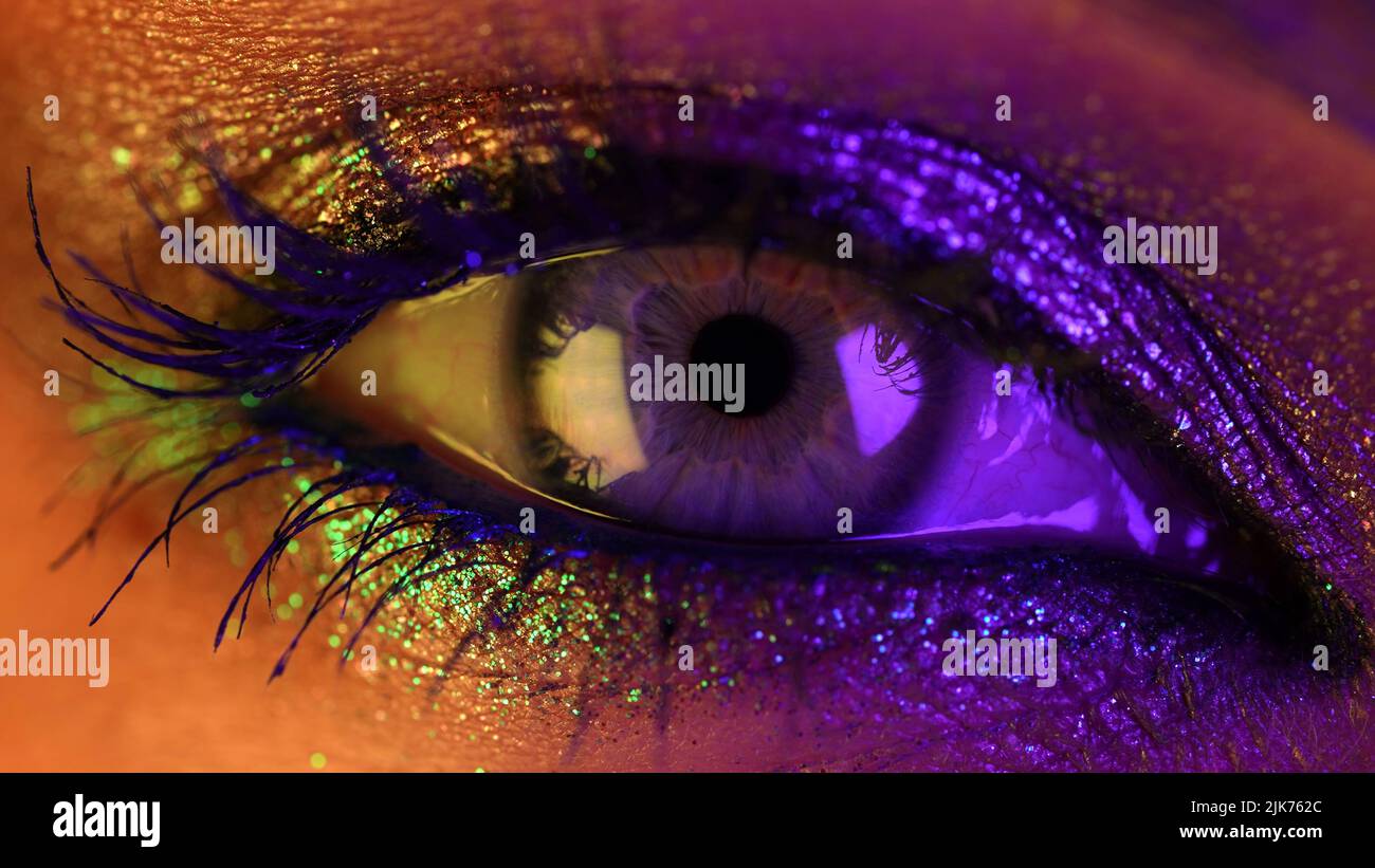 Close-up of woman eye under neon light. Female with beautiful makeup ...