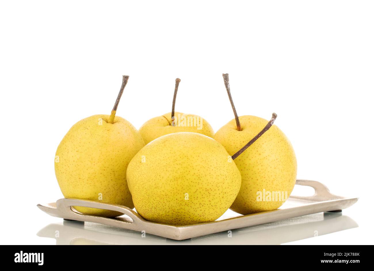 Four organic bright yellow pears on a metal tray, close-up, isolated on ...