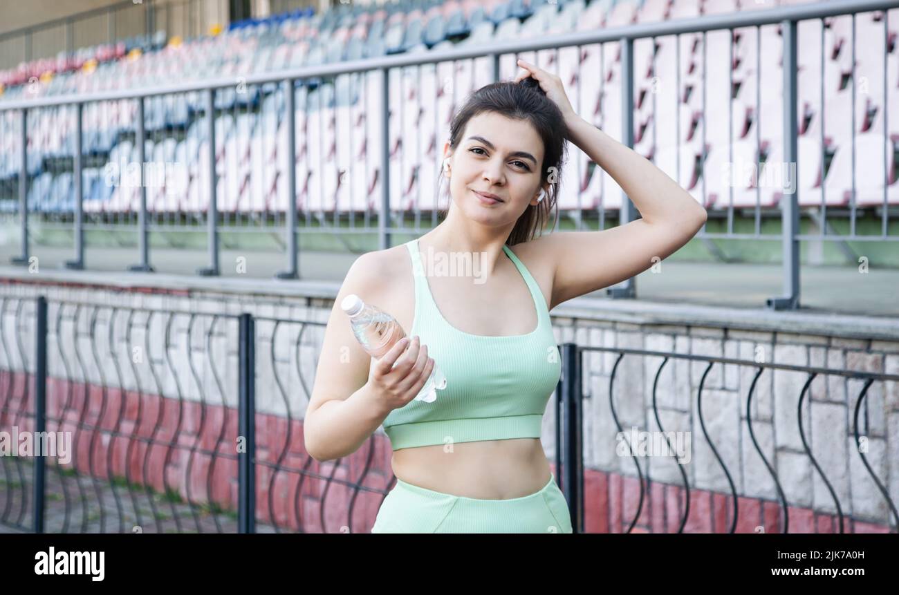 A young woman with a bottle of water in training at the stadium Stock ...