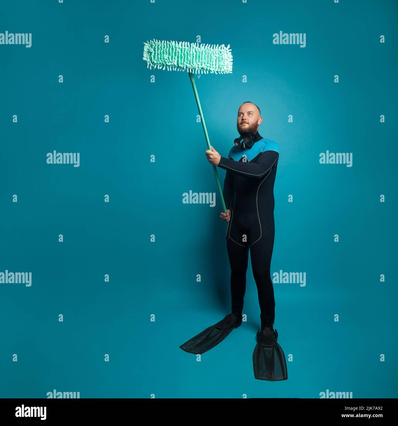 Ocean pollution and environmental protection concept. Diver with mop on ...