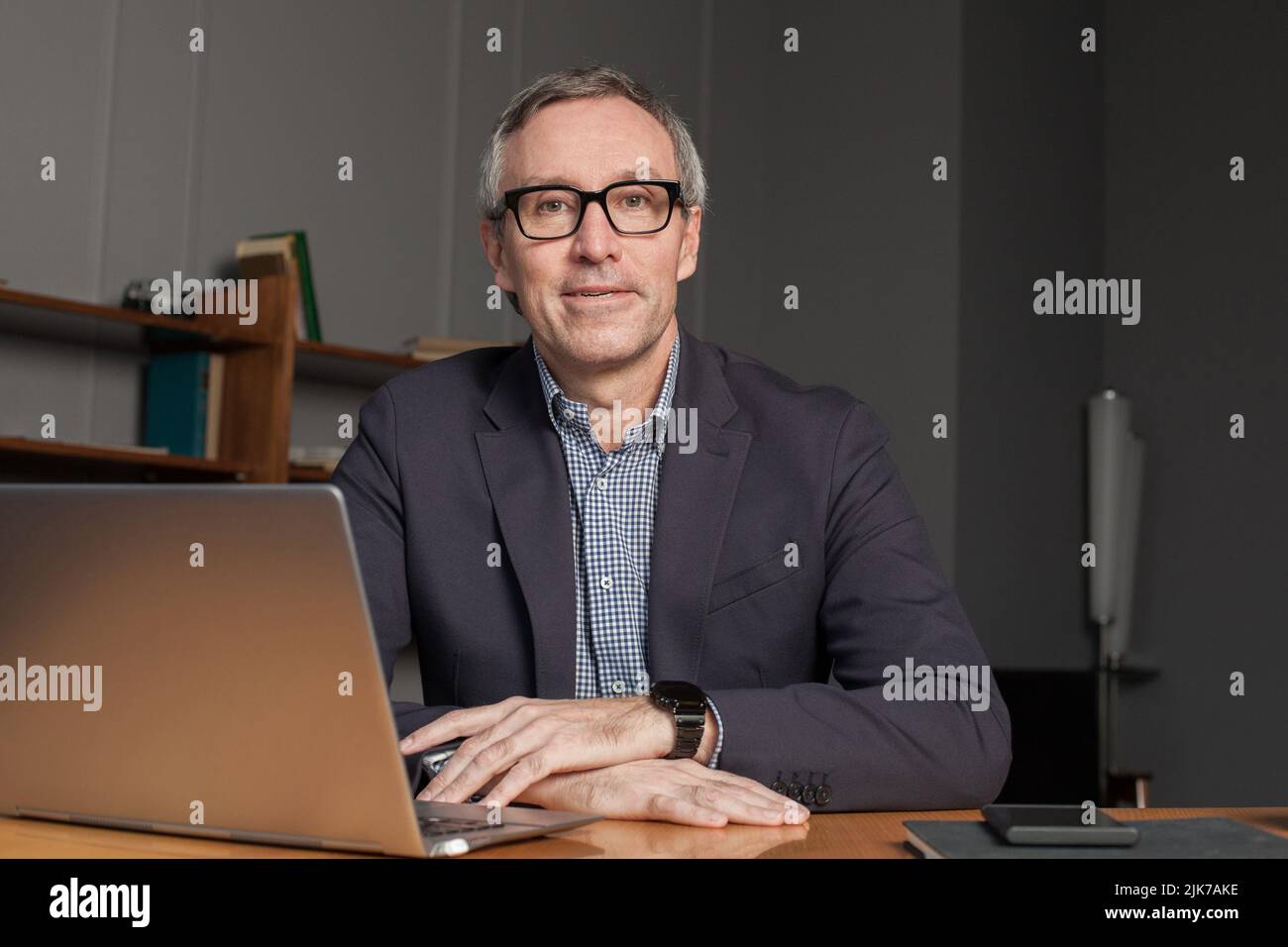 Mature man with laptop computer smiling indoor Stock Photo - Alamy