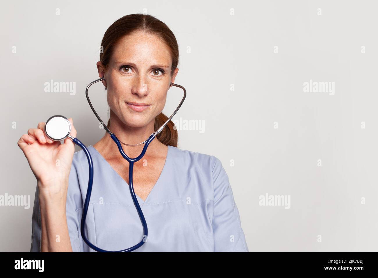 Head shot of woman professiona medical worker wearing blue medical coat ...