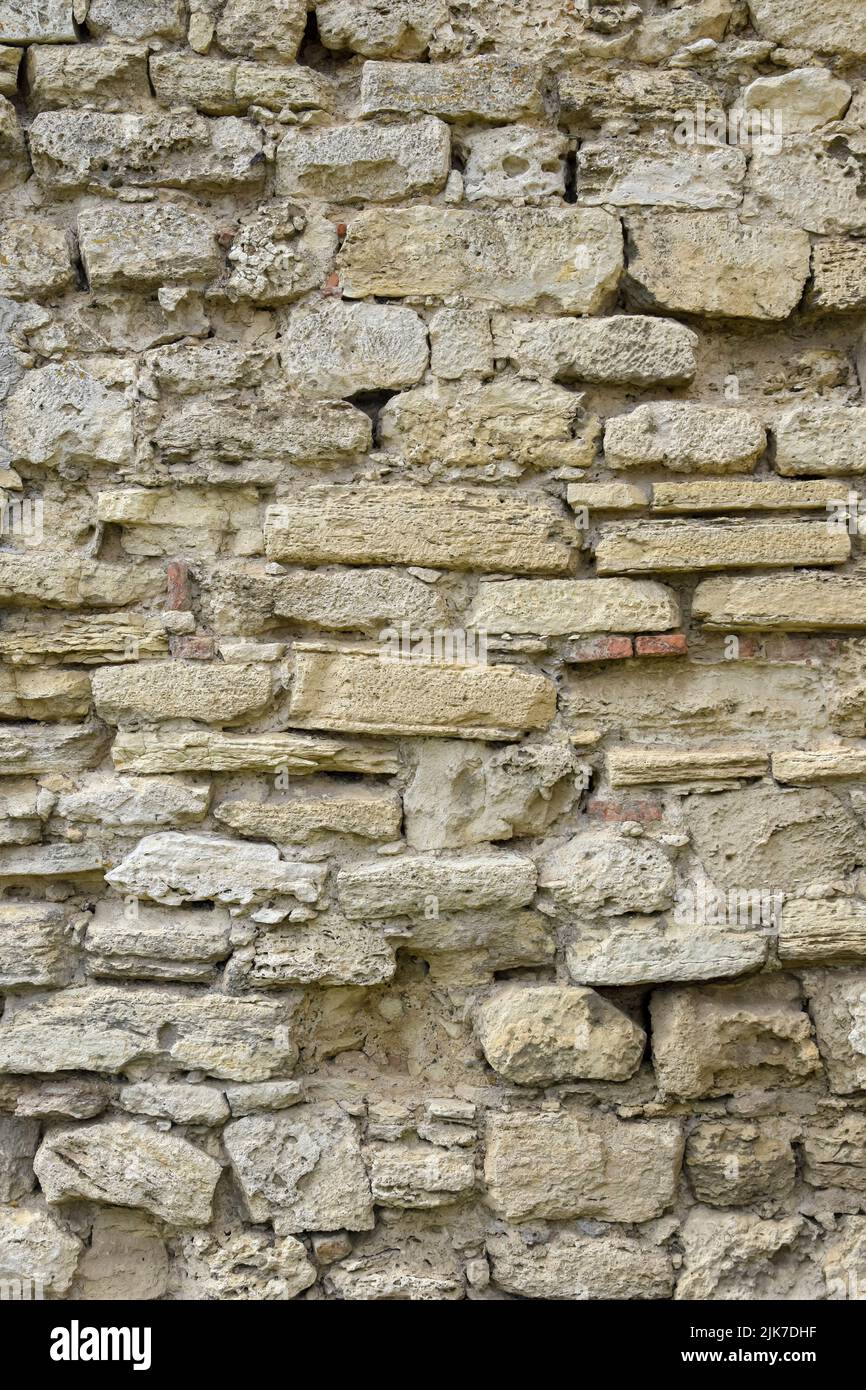 Masonry wall of old stone blocks of limestone. Background texture of ...