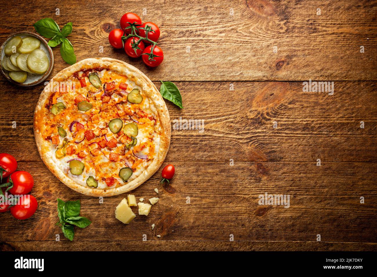 Tasty cheeseburger pizza and cooking ingredients tomatoes and basil on ...