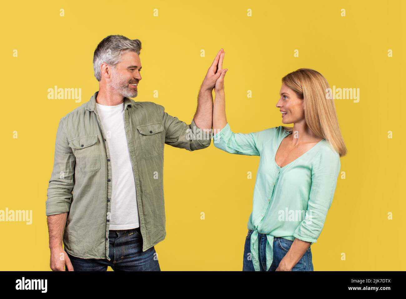Common success. Happy middle aged man and woman greeting each other ...