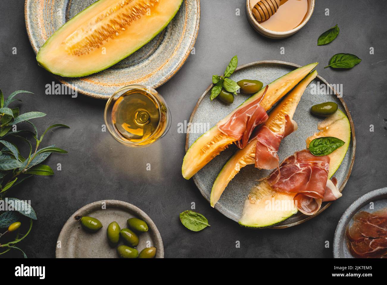 Jamon serrano, ham or prosciutto with melon and olives, a traditional ...