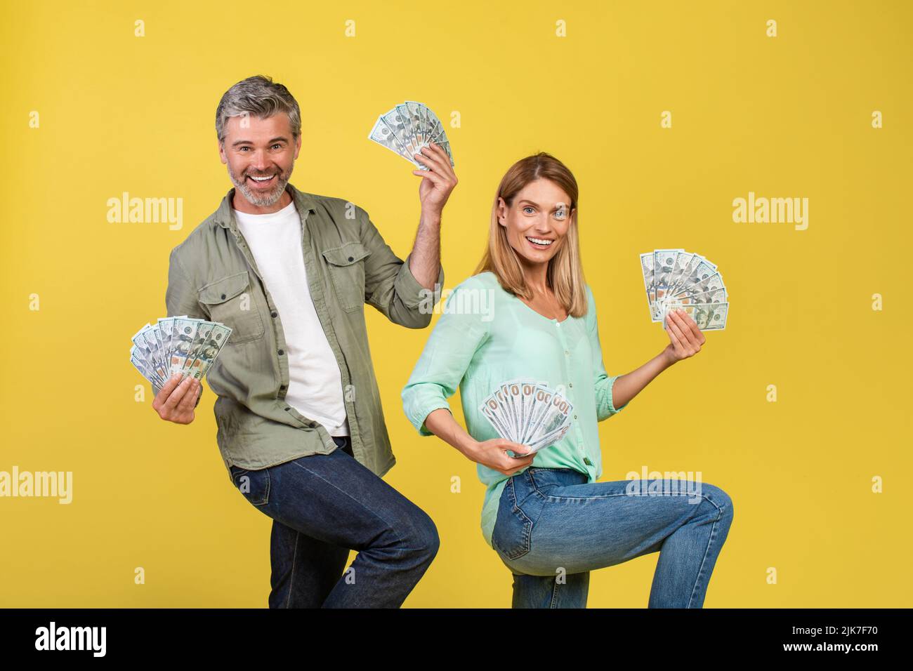 Excited mature couple dancing with bunch of money banknotes and ...