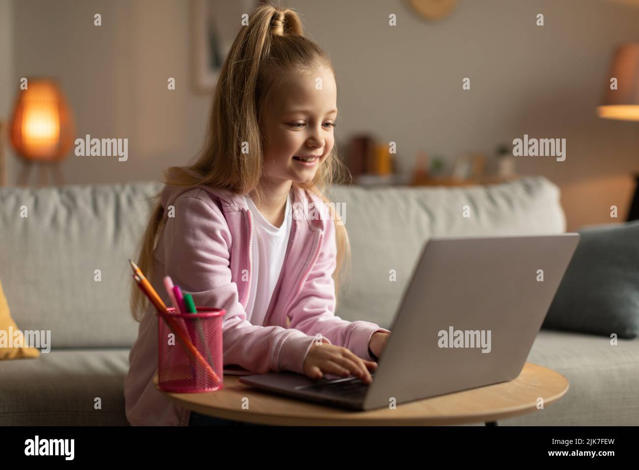 School Kid Girl Typing Using Laptop Learning Online At Home Stock Photo ...