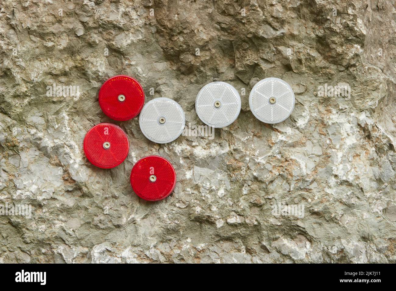 red and white plastic reflection items fixed on a stone Stock Photo - Alamy