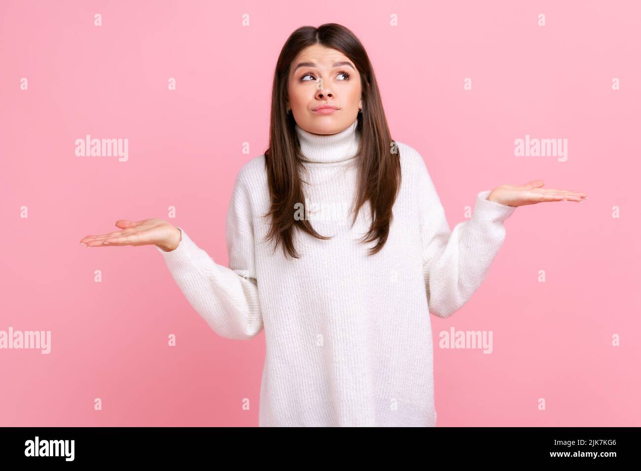 Ambiguous confused dark haired female standing with raised arms ...
