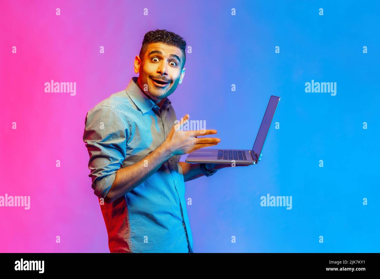 Portrait of amazed handsome man in shirt watching shocked video, having ...