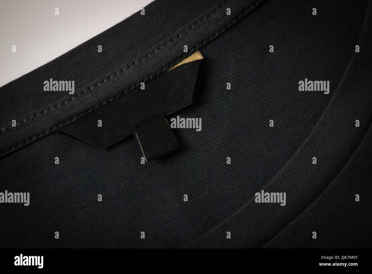 Black blank clothes label on black fabric texture background. Top view ...